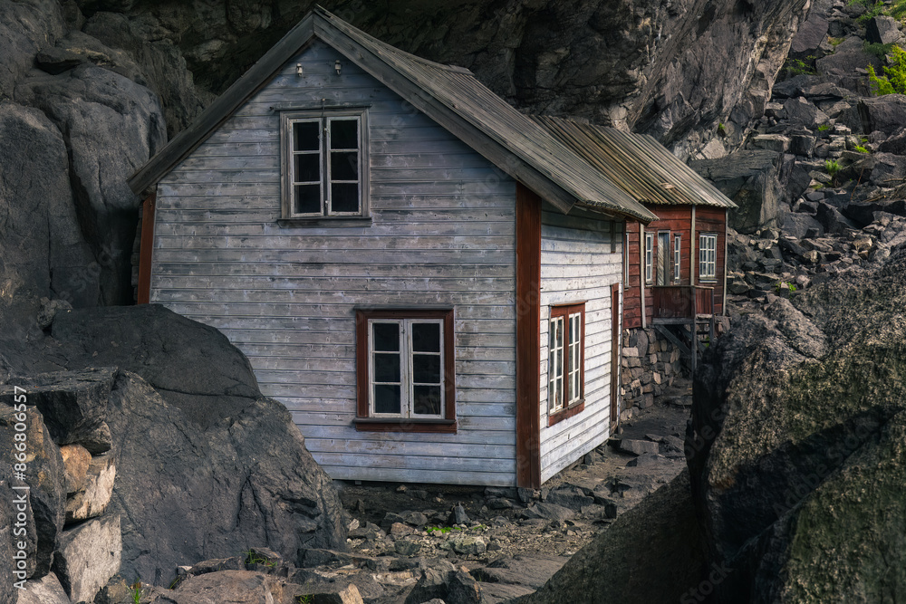 Historic preserved wooden houses nestled under the rock overhang at ...