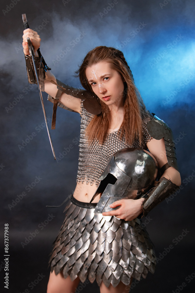 Portrait of a medieval female warrior in armor with a sword and helmet ...