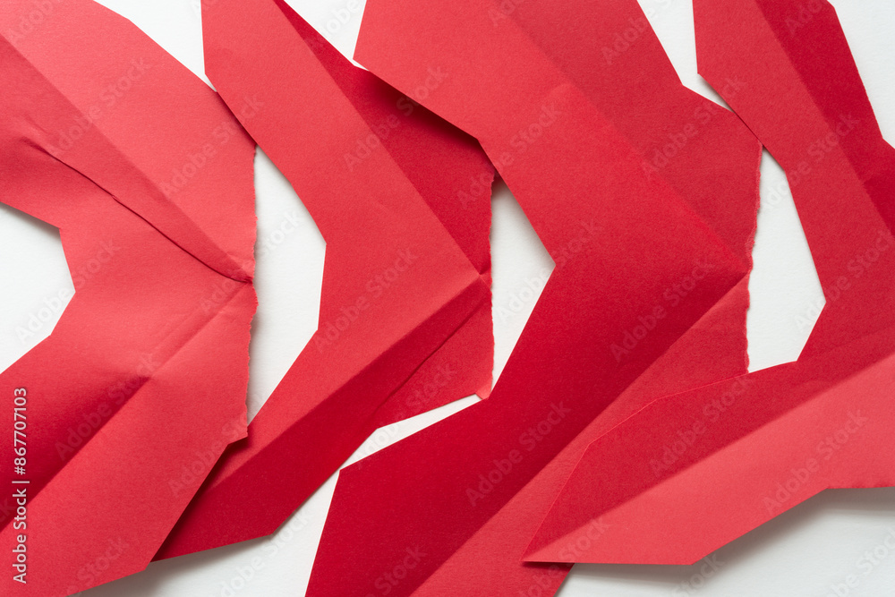 folded, cut, and torn red paper shapes in 3d form arranged as arrows ...