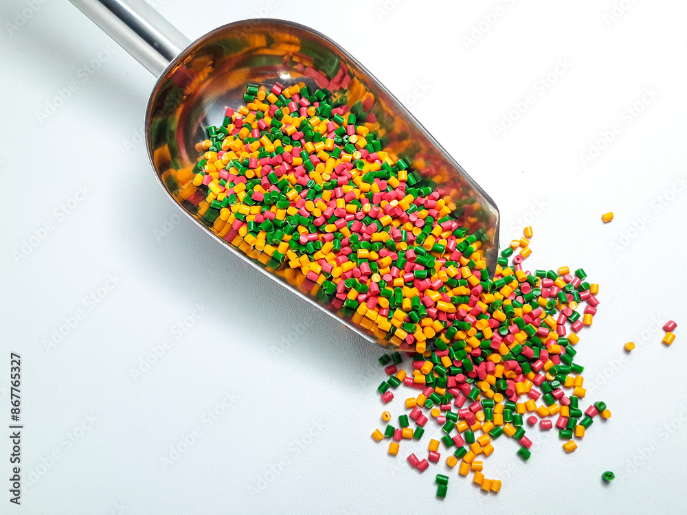 Colorful masterbatch granules mixed in a scoop, isolated on white ...