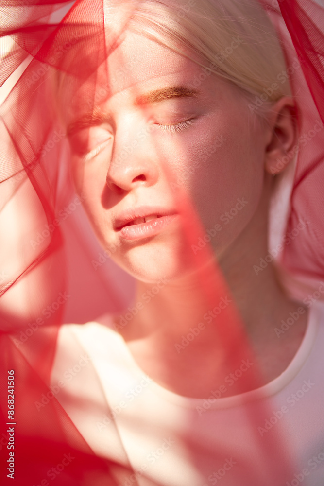 Vertical portrait of albino girl, pretty woman model wearing red veil ...
