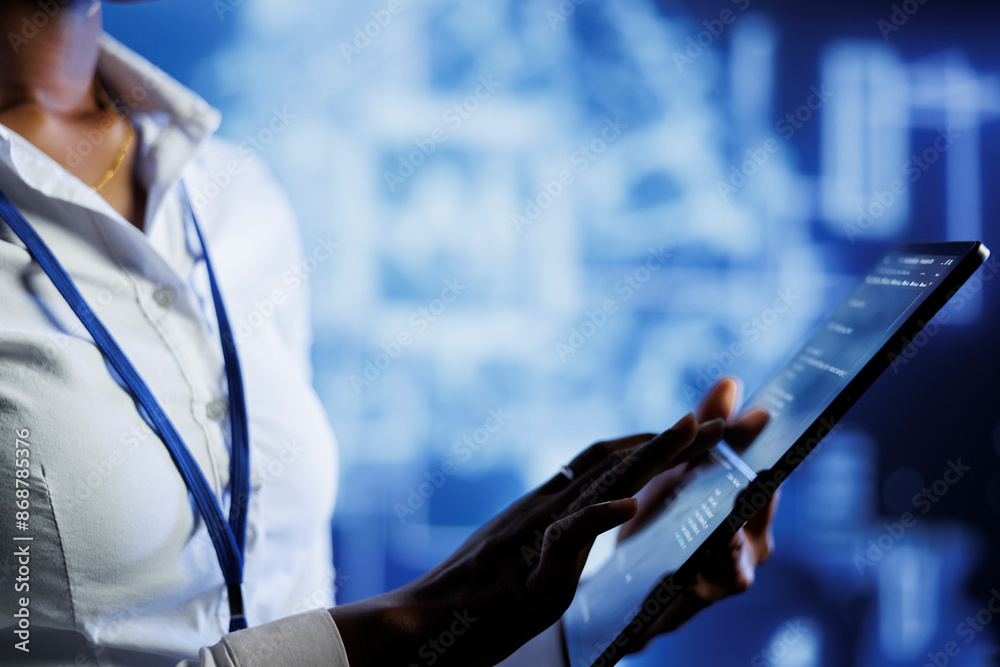 BIPOC computer operator writes code on tablet to visualize artificial ...