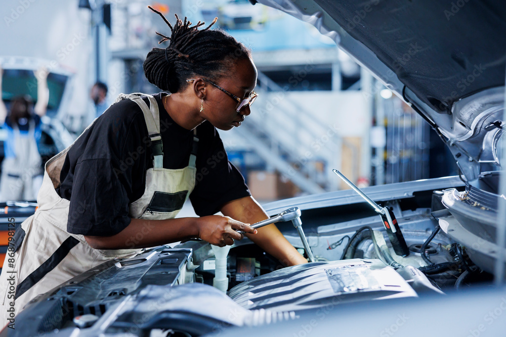 Repair shop technician examines out of order car engine using advanced ...