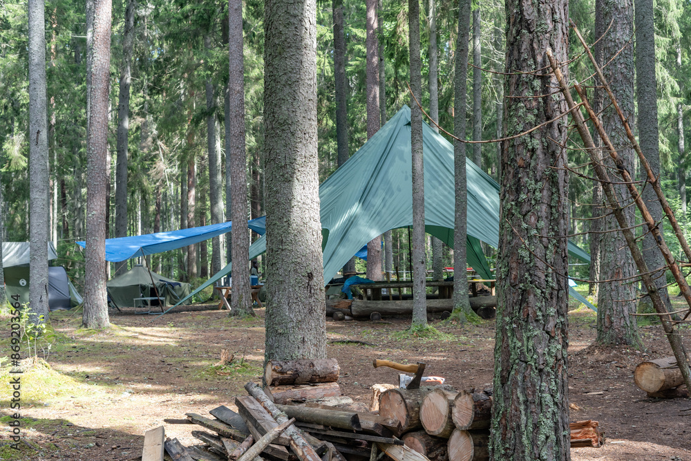 Large shelter tent stretched above the wooden table and benches in ...