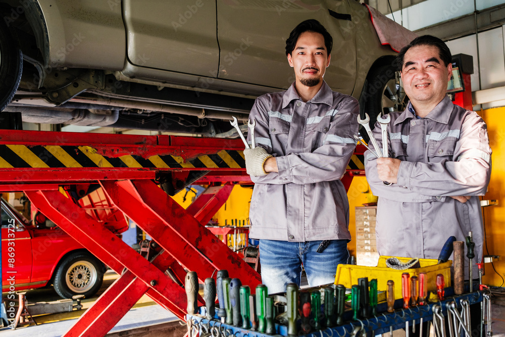 Diversity mechanic teamwork, a Thai and Japanese man in blue uniforms ...