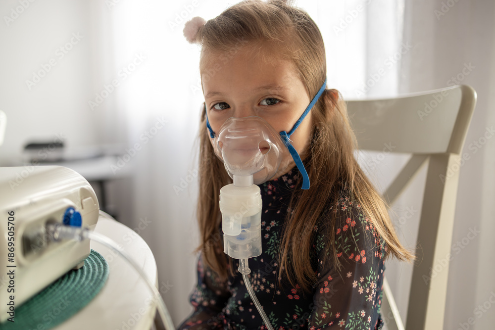 Cute little girl in the mask of an inhaler. Procedure of inhalation at ...