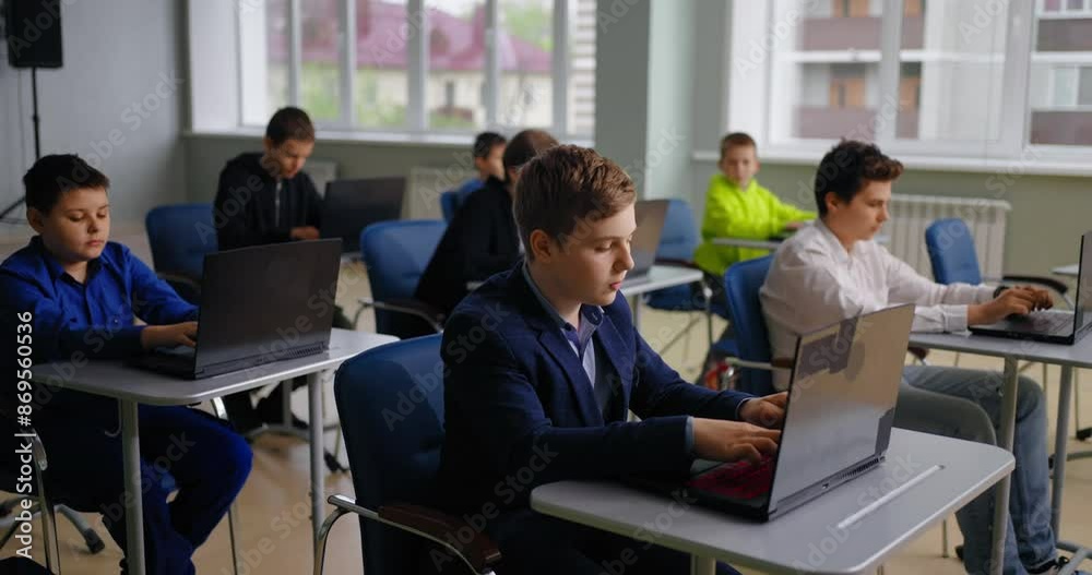 Diverse Teen Boys Sitting At Tables With Modern Laptops In Computer ...