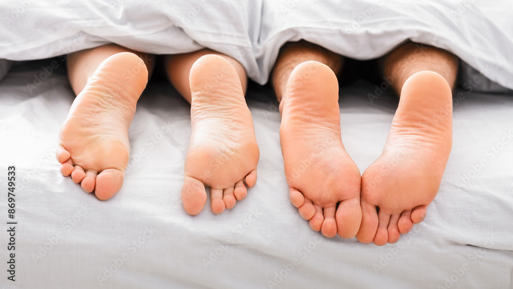 A close-up image of two feet, one on each side of the frame, resting on ...