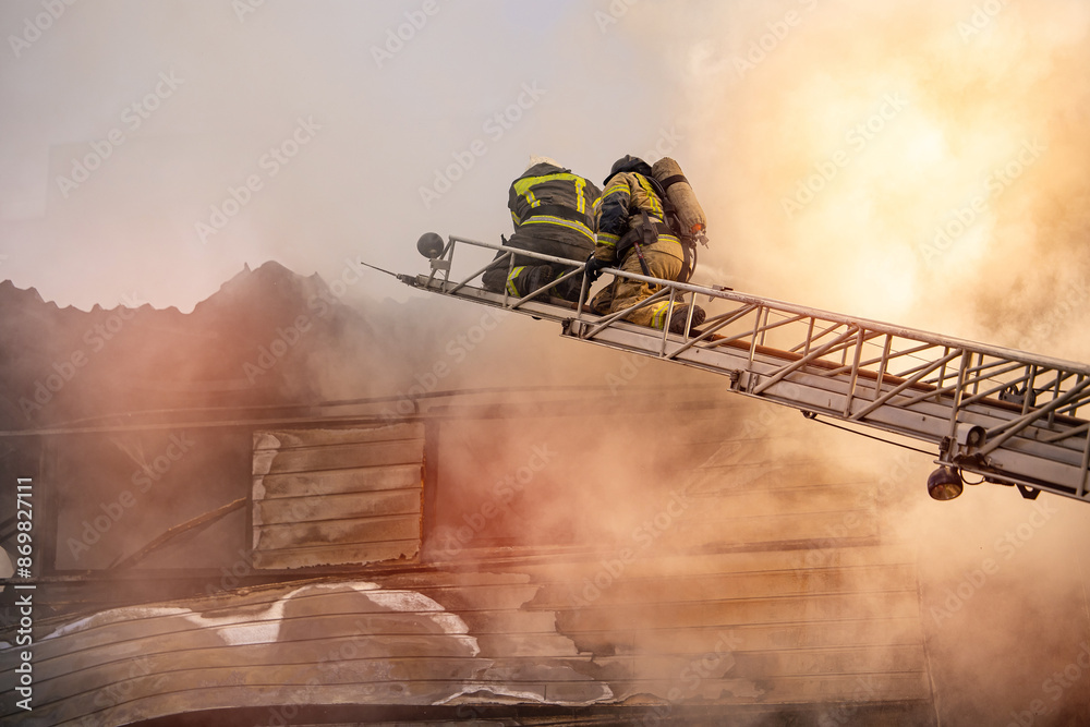 Fireman team extinguishes burn with hose water from ladder of aerial ...