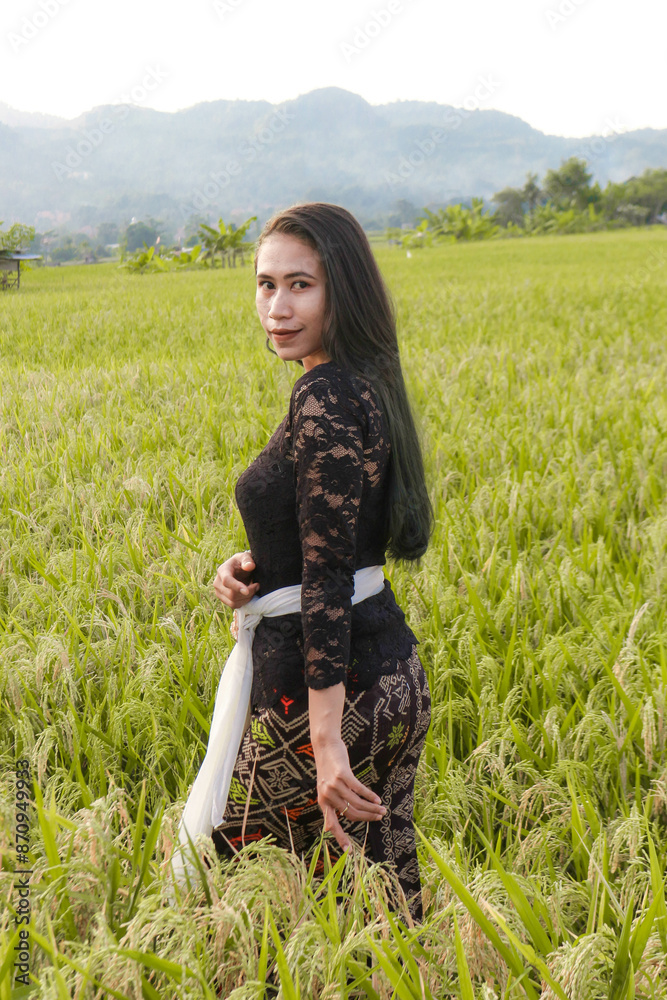 portrait of an Indonesian woman wearing a black Balinese kebaya in a ...