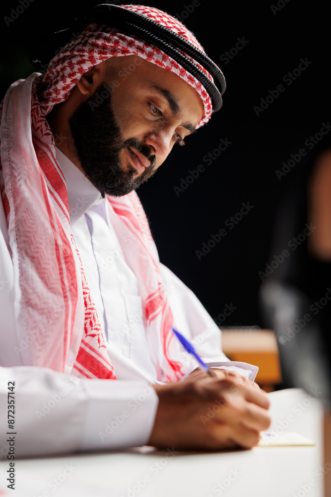 The image portrays an attentive Middle Eastern guy in traditional ...