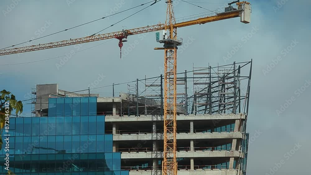 High-rise building under construction, featuring a prominent crane and ...
