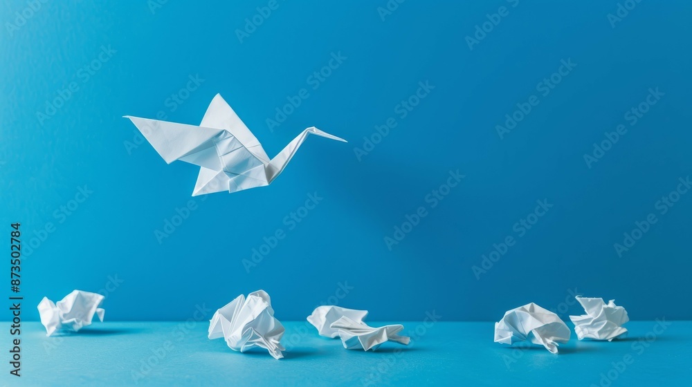 Origami crane soaring above crumpled paper. A white origami crane takes ...