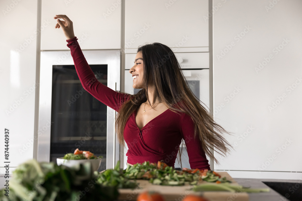 Happy active Indian dancer girl preparing healthy lunch in kitchen ...