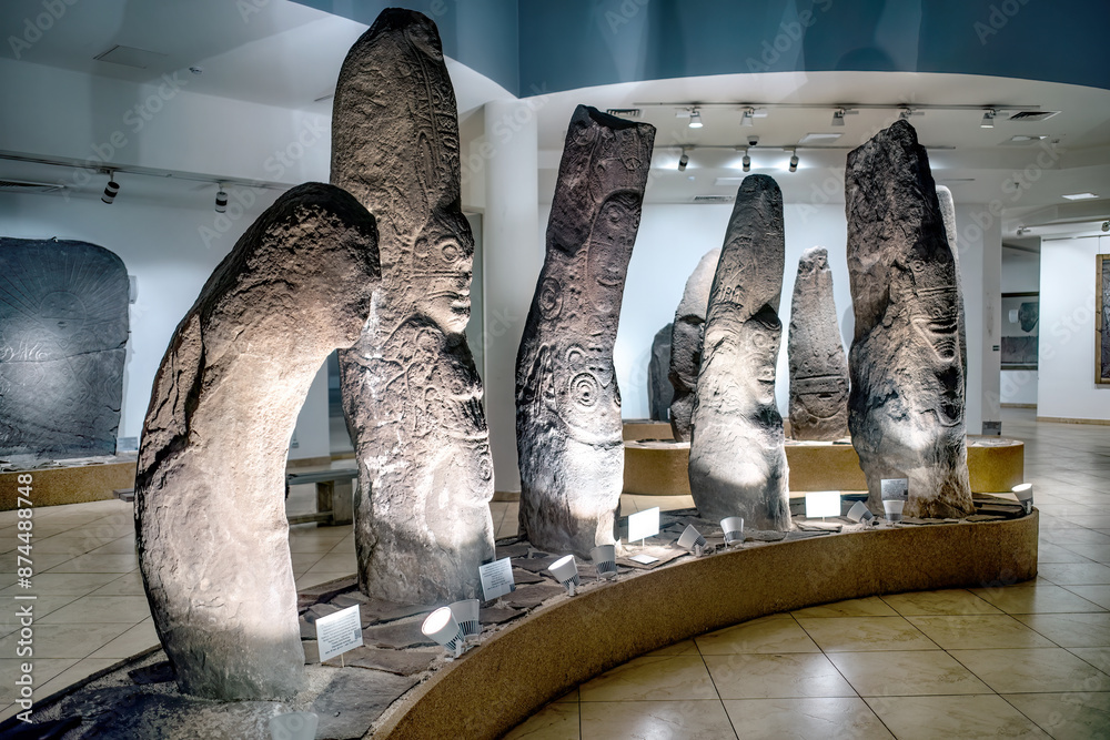 Ancient burial mounds with faces of various creatures and pictograms in ...