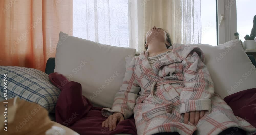 Very tired, exhausted woman sitting on the couch in a mess with no ...