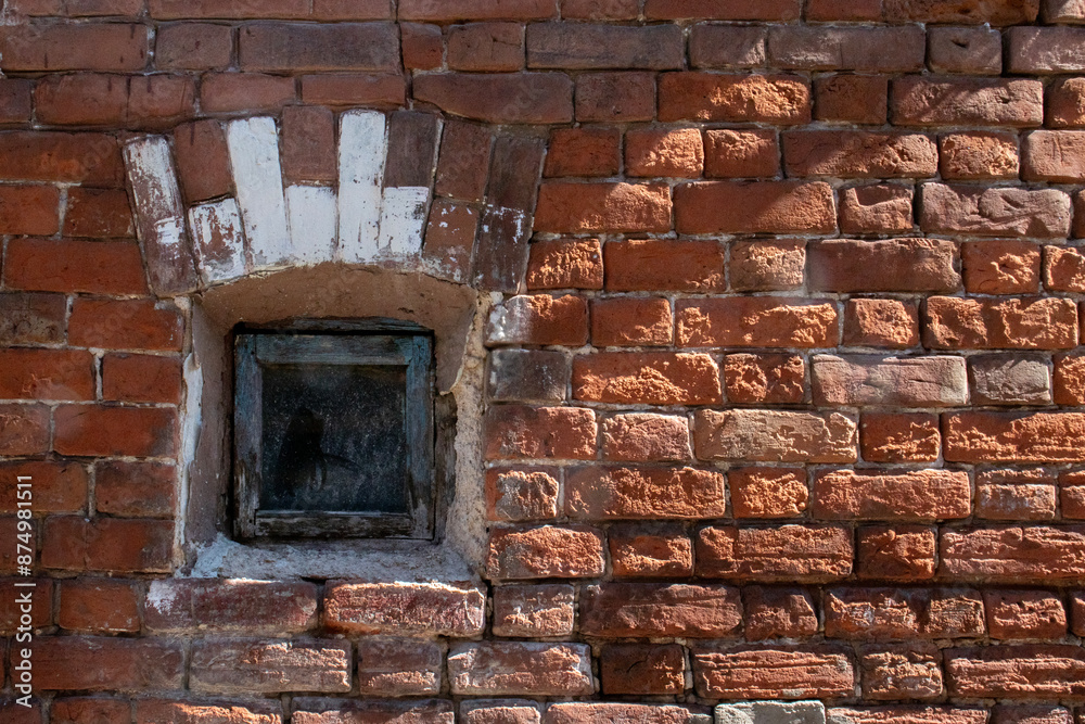 Window on a brick wall. A small window on the wall of a red brick house ...