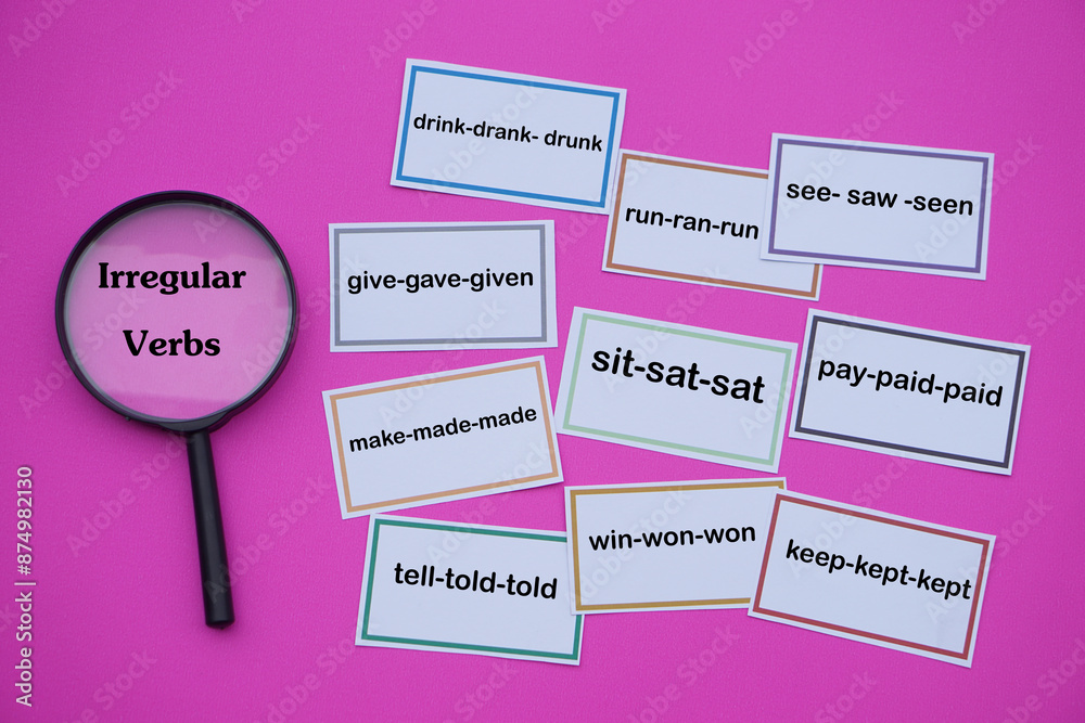 Paper word cards of irregular verbs and magnifying glass. Pink ...