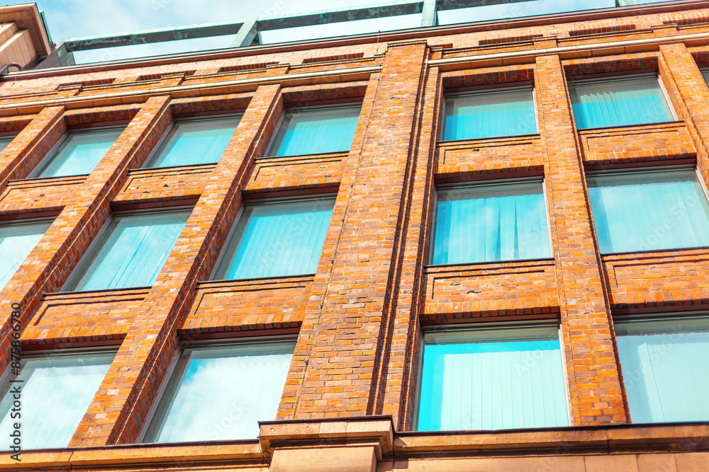 Tall building with numerous windows, reflecting the sunlight on a clear ...