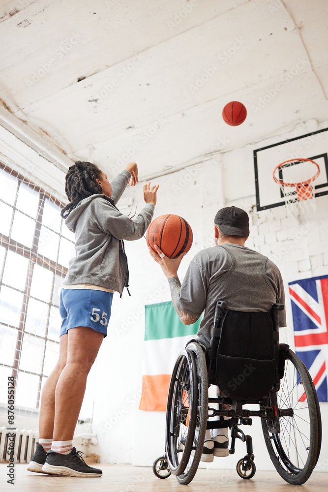 Vertical back view of sportsman using wheelchair in basketball practice ...