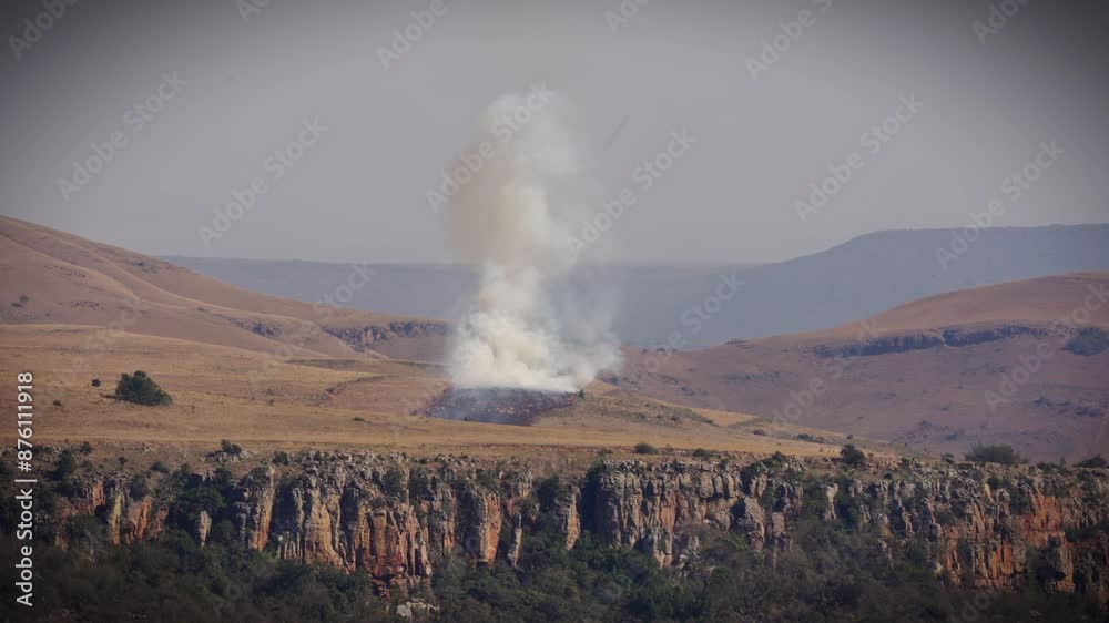 An out of control field forest burning bellowing smoke into the air and ...