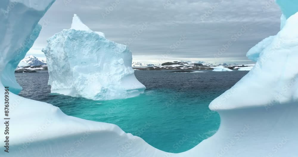 Cracked hole in melting iceberg in Antarctica ocean close up. Drone fly ...