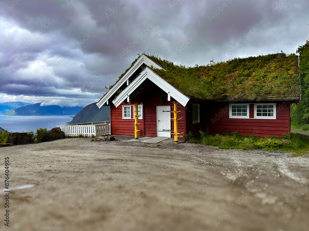 The house is red with a white trim and green roof, looking picturesque ...