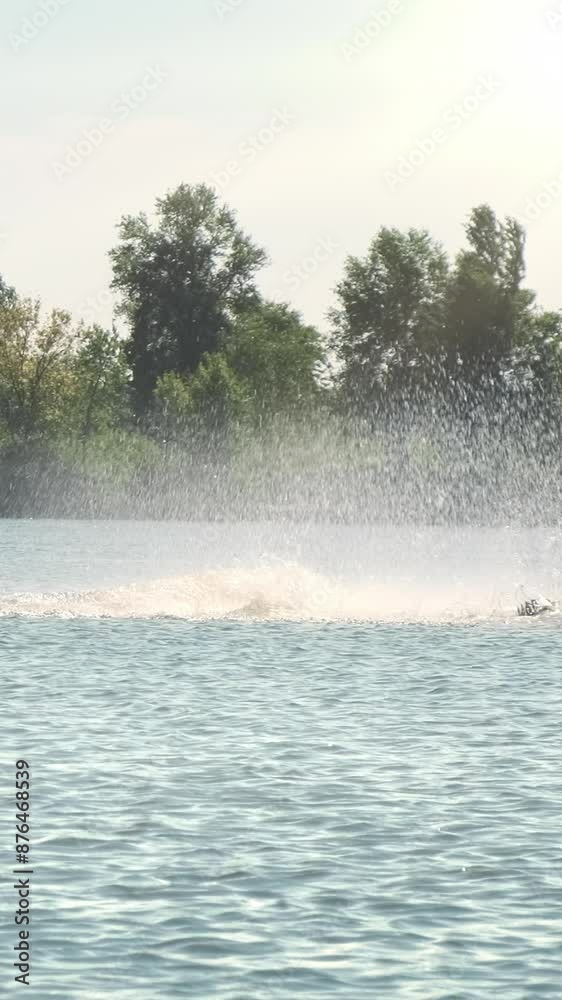 Vertical video, Man falling from electric surfboard on blue water ...