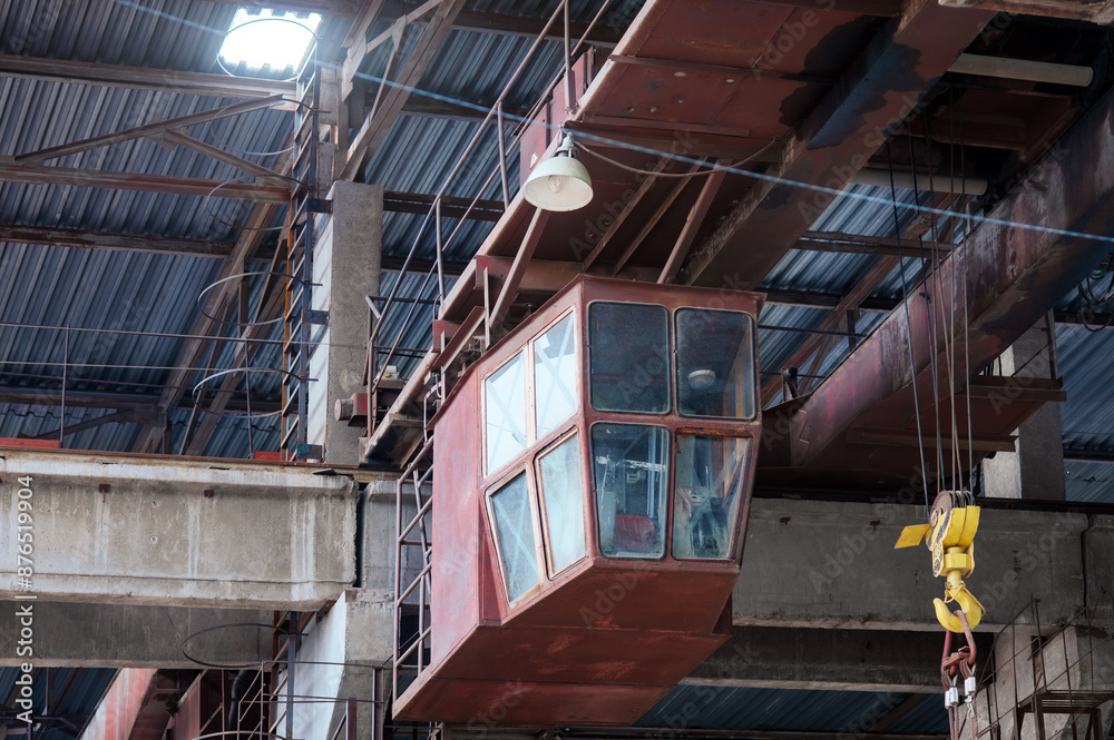 Overhead crane with a linear cross-beam and a yellow hook in the shop ...