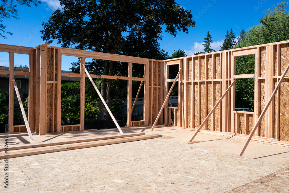 Wood framing started on new home construction job site, exterior walls ...
