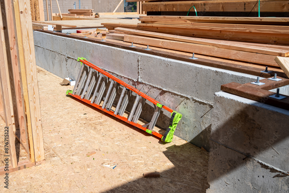 New home construction detail, ladder leaning against cement foundation ...