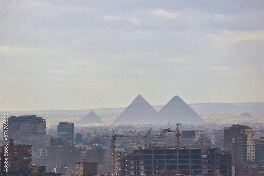 The Great Pyramids of Giza looms over the modern and dusty Cairo ...