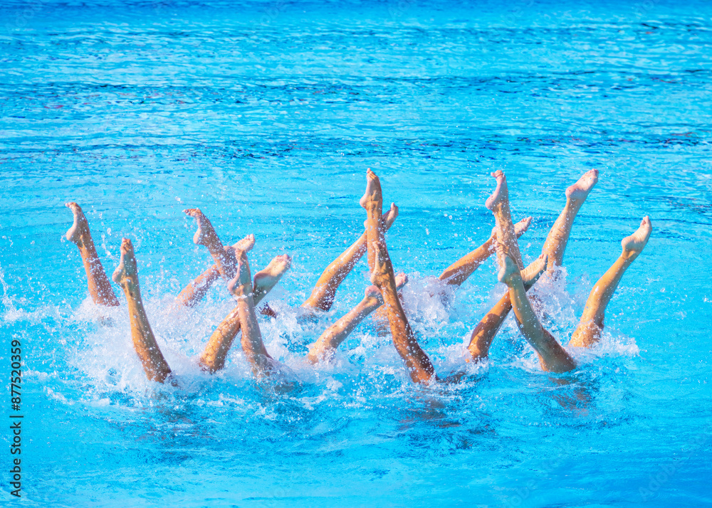 Artistic swimming team performing synchronized legs movement in ...