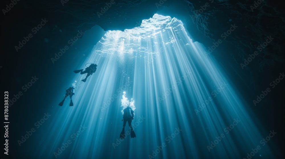 Group of scuba divers navigating through an underwater cave system ...
