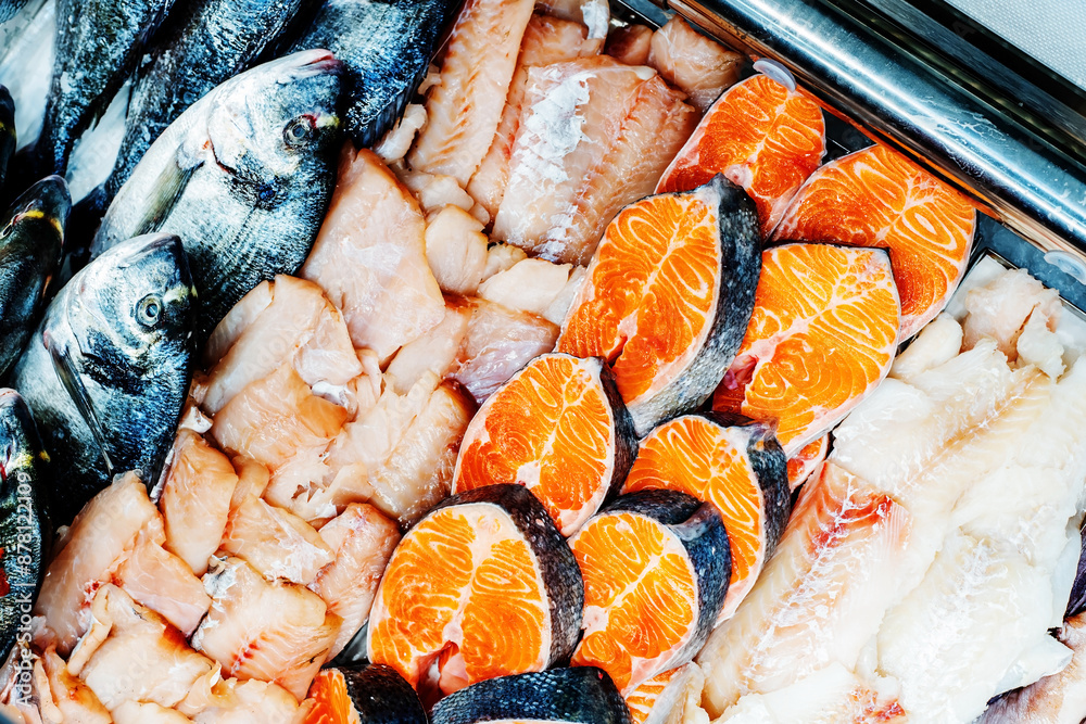 A close-up view of fresh fish on display in a market. The fish include ...