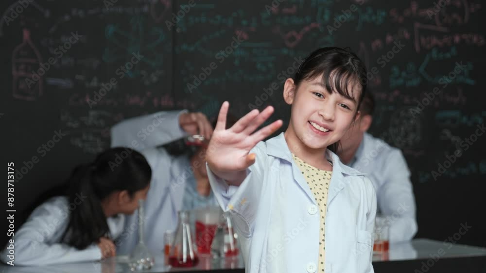 Cute asian scientist waving hand to camera while diverse group doing ...