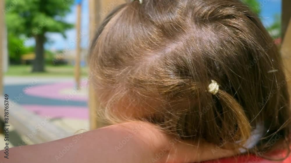 Upset crying baby girl on the playground at swing. Children playing ...