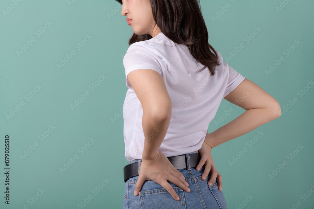 Coccyx pain. adult female with muscle pain on green background. asian ...