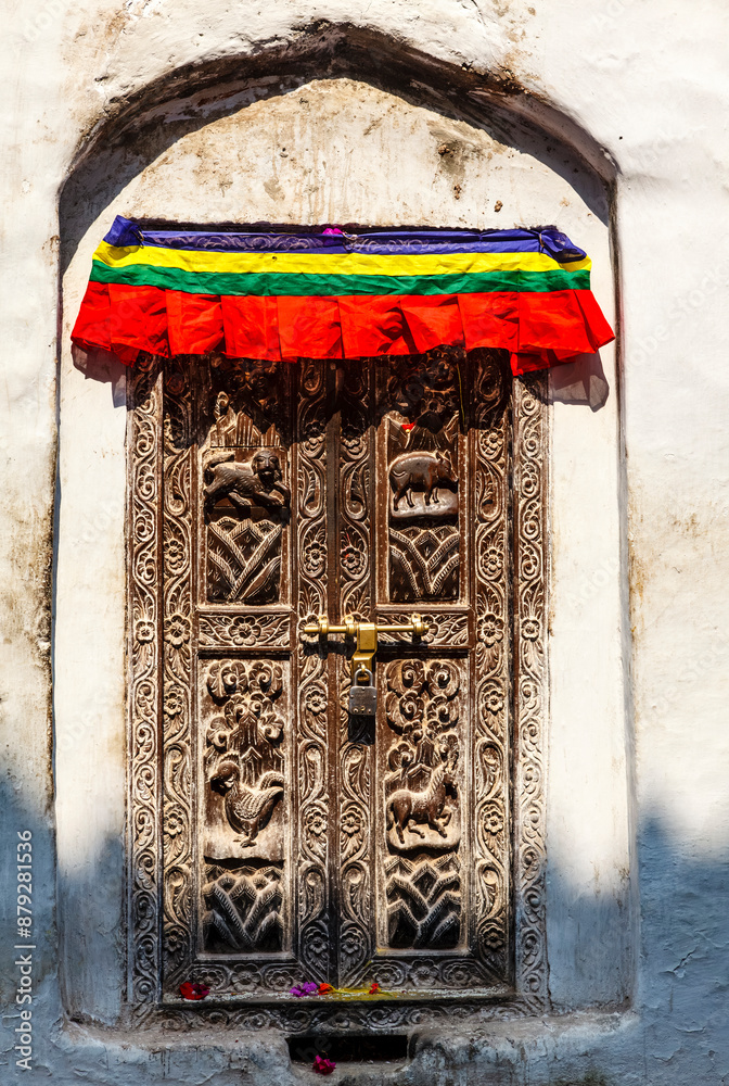 Old wooden door with animal carvings in the facade of the Bouddha, also ...