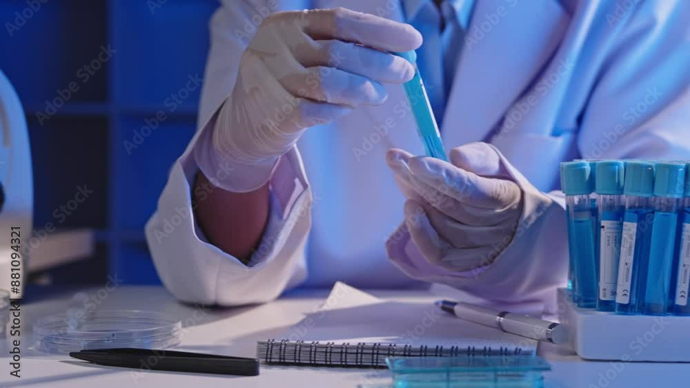 Scientist in lab coat carefully handling test tubes for analysis ...