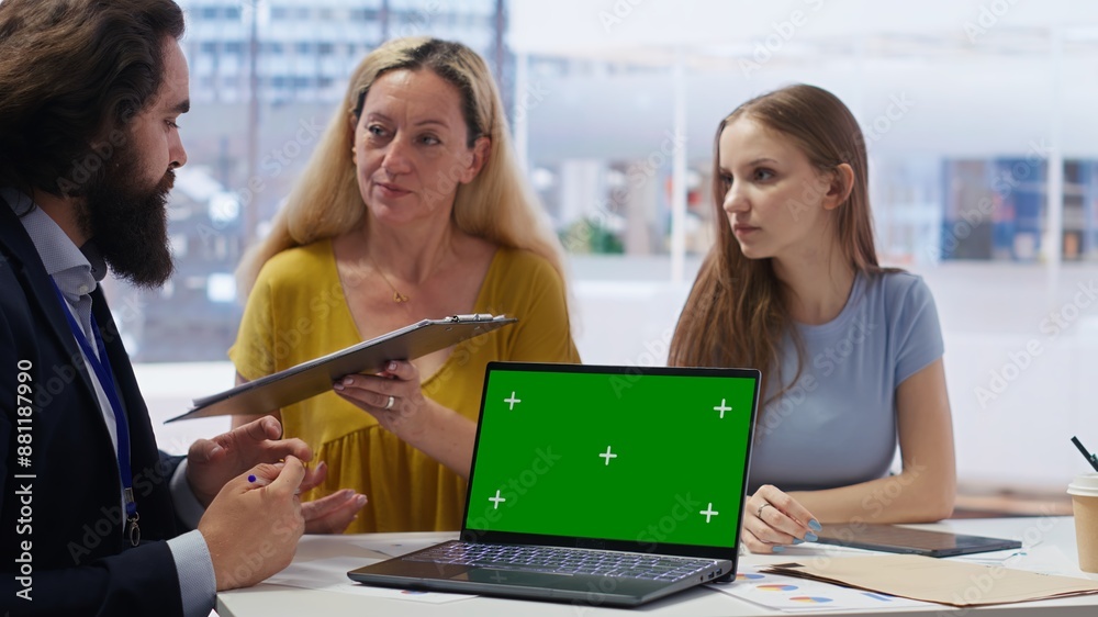 Clients looking over personalized planning guide on green screen laptop ...