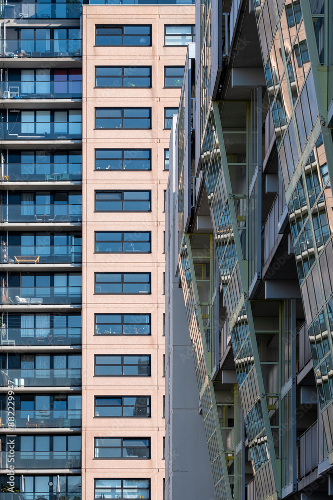 The image captures a contrast between two tall buildings: one with a ...