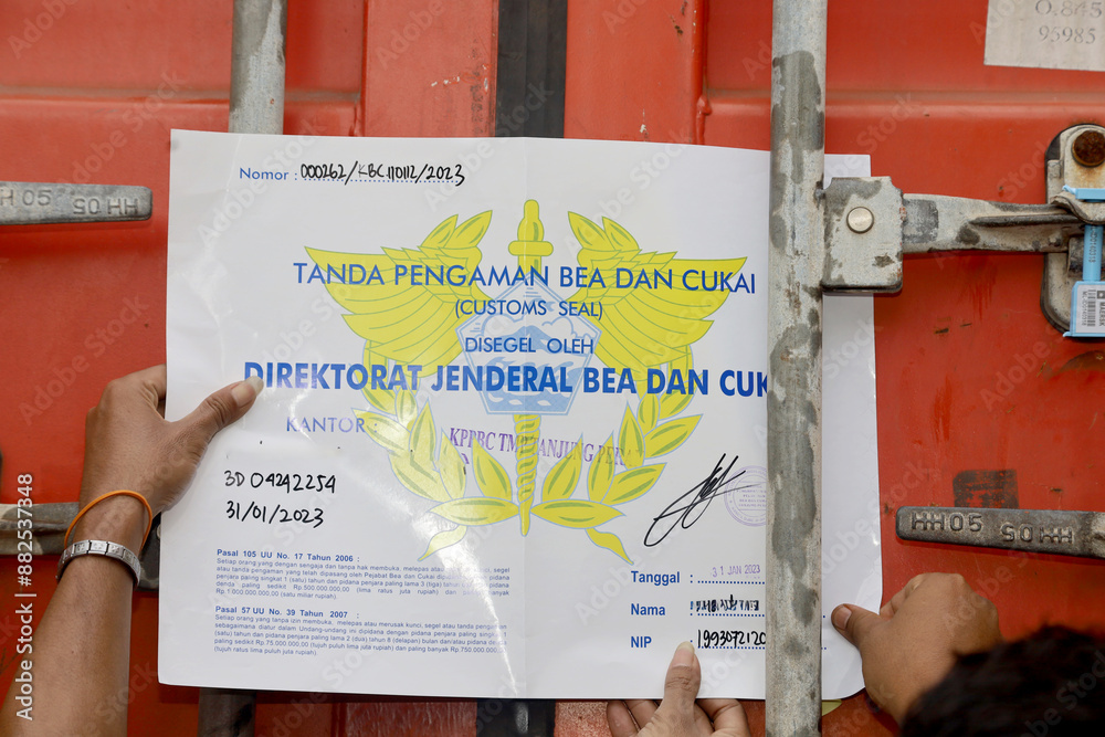 Indonesian customs officers seal containers after loading goods for ...
