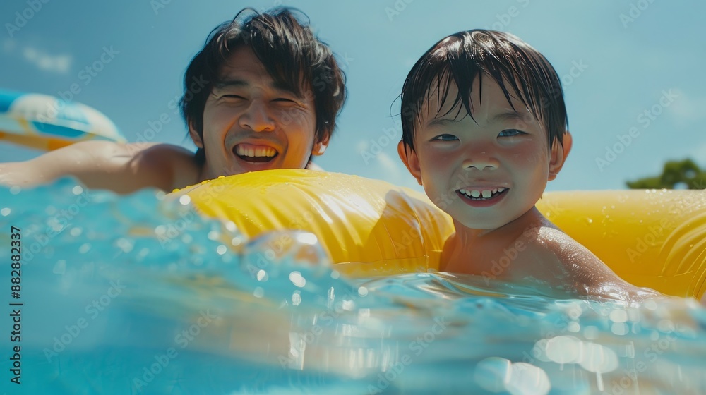 Smiling Japanese parent and child playing in a float in a beautiful ...