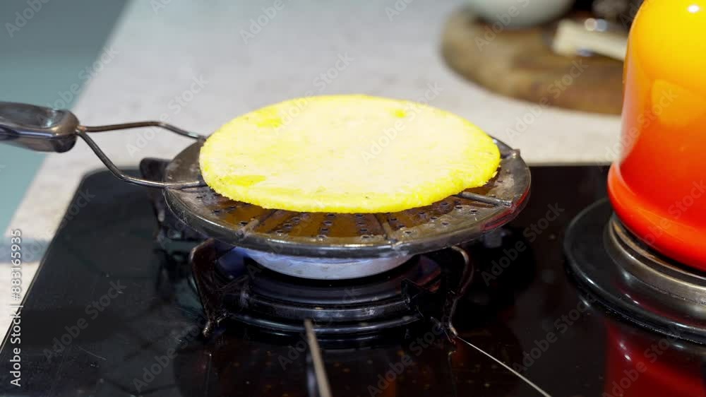 Making Arepas: Traditional Cooking. Hands roast an arepa on a stove ...