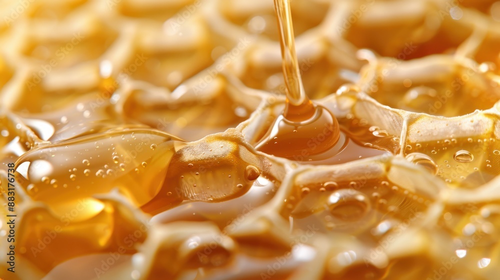 Honey being poured into honeycomb cells, showcasing its golden color ...