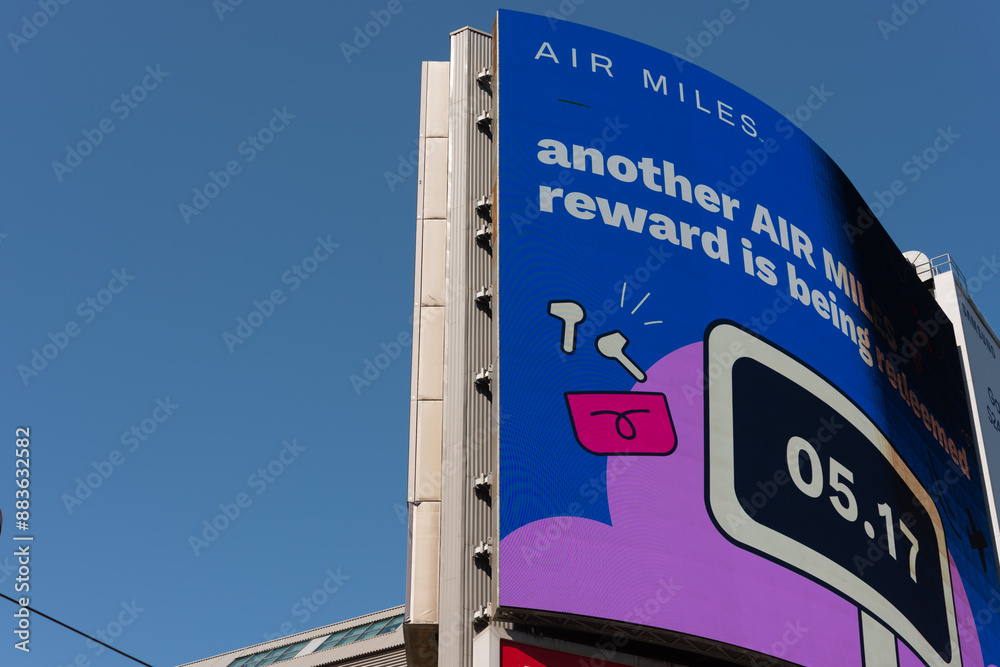 skyward glance at an LED billboard (featuring Air Miles ad) on a blue ...