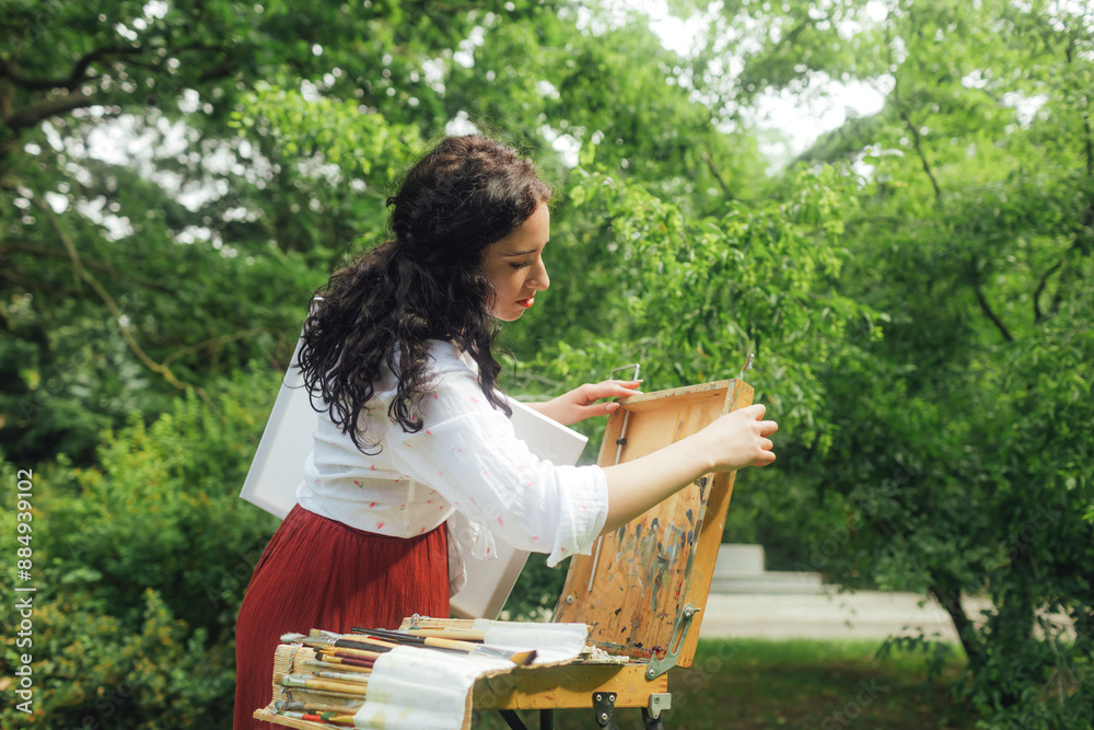Female artis paints a picture in the park. Mindfulness, art therapy ...