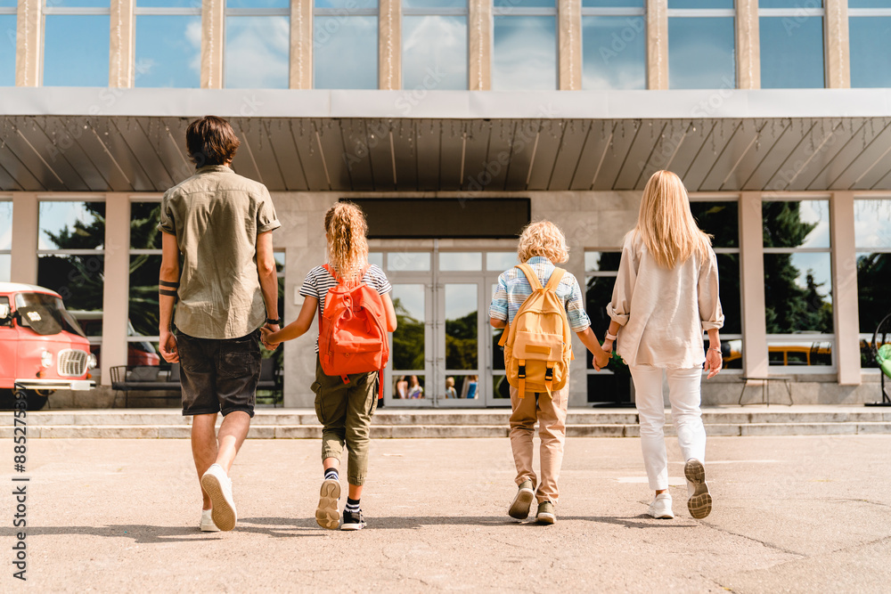 Young parents seeing their kids children to school for lessons classes ...