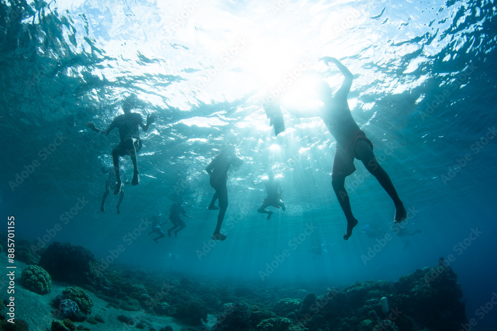 Children from a local village swim in the shallows above a coral reef ...